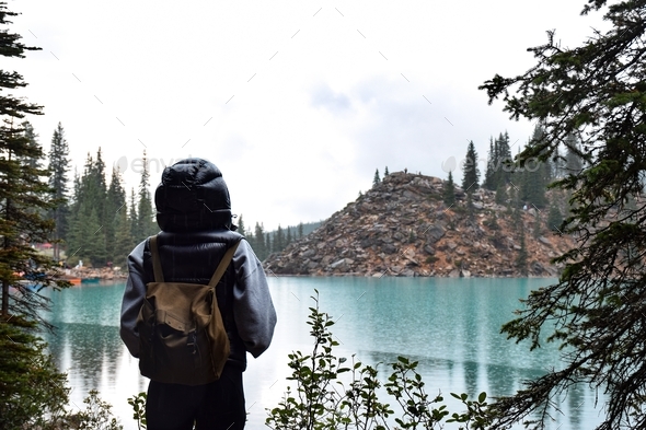 Girl with backpack looking at the Rockpile trail at Moraine lake in ...