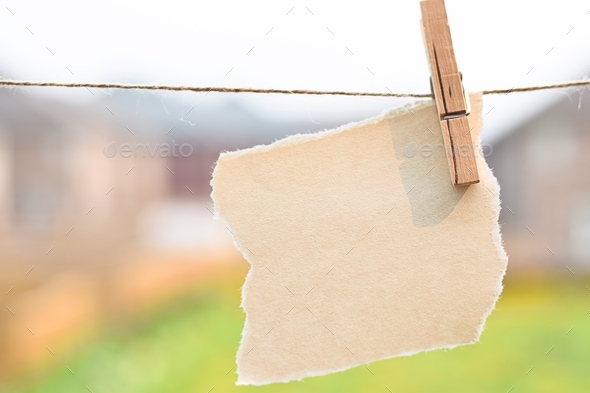 Blank torn paper note hanging on a string with clothespin ready for ...