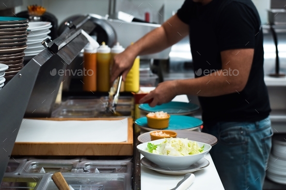 Restaurant kitchen employee preparing food order for customer Stock ...
