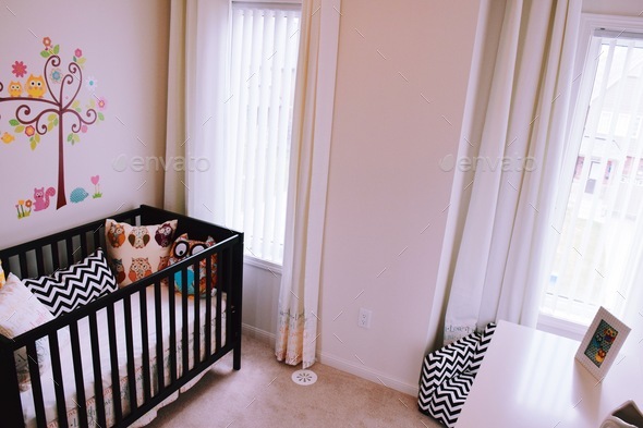 Light and bright baby nursery with a mural above the crib Stock Photo ...