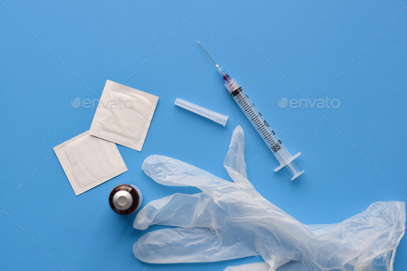 Syringe, a medication vial, disposable gloves and alcohol wipes for an ...