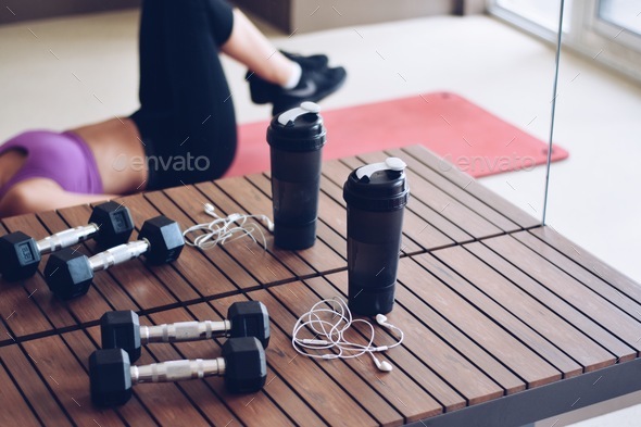 A reflection in a mirror of a girl working out on a yoga mat at the gym ...