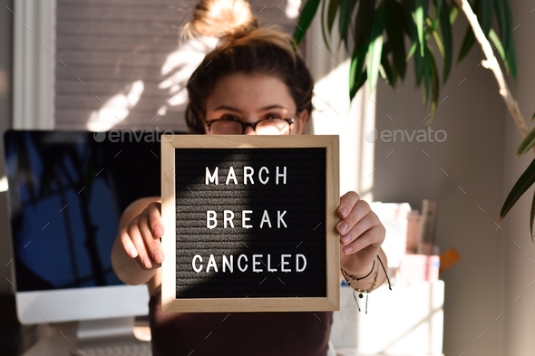 Girl high school student is holding letter board sign that says MARCH ...