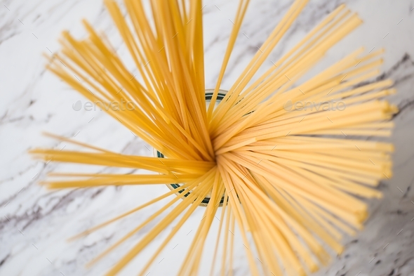 Dry linguine spaghetti pasta fanned out in glass top view on a marble ...