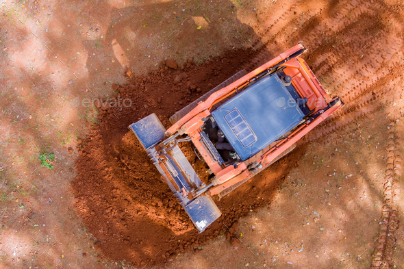 An earth moving tractor is used on a construction site in order to move ...