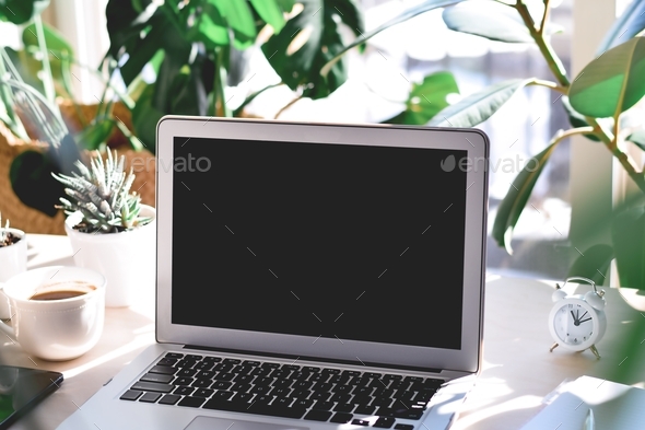 Workspace desk with laptop computer, notebook, cup of coffee, tropical ...