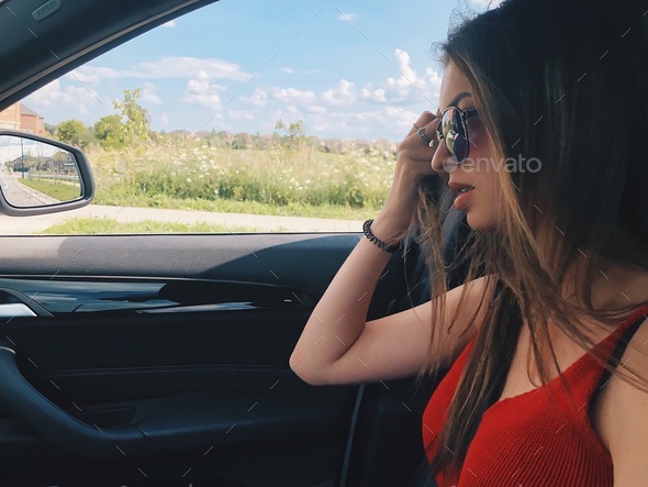 Young girl in sunglasses riding in a car with windows down Stock Photo ...