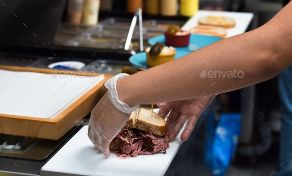 Restaurant kitchen employee working on preparing customer food order ...