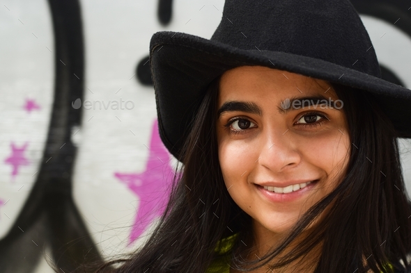 Closeup portrait of young girl in fedora hat smiling looking at camera ...