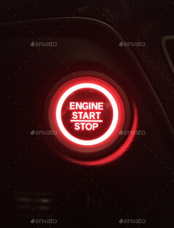 Modern automobile illuminated engine start stop ignition button in red ...