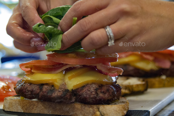 Putting toppings on gourmet hamburger Stock Photo by RLTheis | PhotoDune