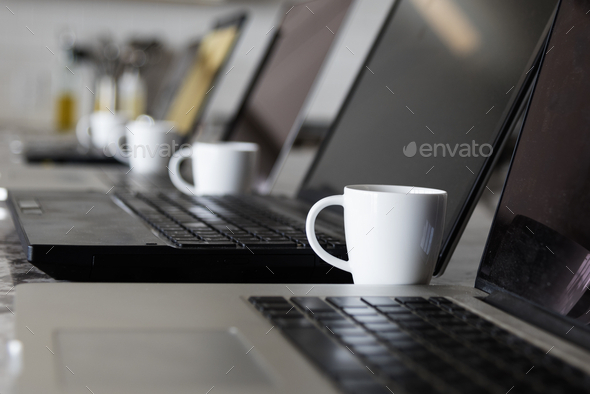 Espresso and laptop computers lined up on office table. Stock Photo by ...