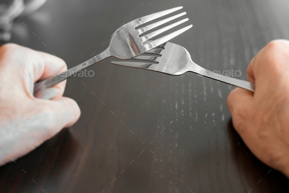Point of view hands holding two forks while at dining table. Stock ...