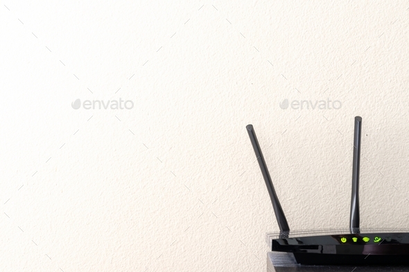 Wifi router with glowing green power connection lights and antenna with ...