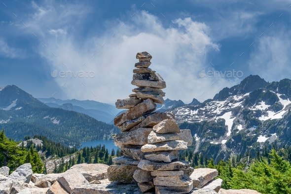 Mountain peak cairns. Stacked rocks trail marker with beautiful forest ...