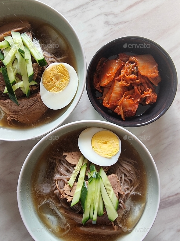 Korean cold noodles in cold beef broth served with slices of beef ...