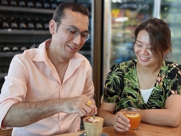 Malaysian couple enjoying a drink at the restaurant Stock Photo by weewendy