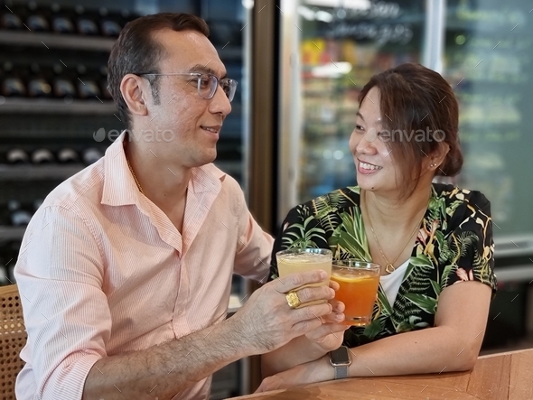 Malaysian couple enjoying a drink at the restaurant Stock Photo by weewendy