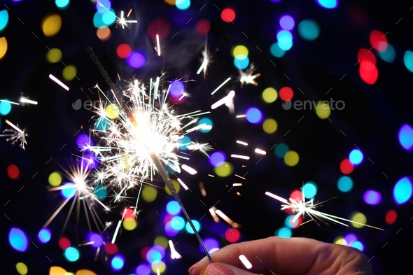 Female holding sparklers shining sparkling with colored lights in ...