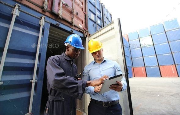 Engineer or supervisor checking and control loading Containers box from Cargo at harbor. Forema ...