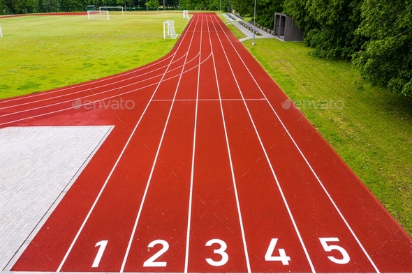 perspective view of an open - air stadium with red numbered running ...