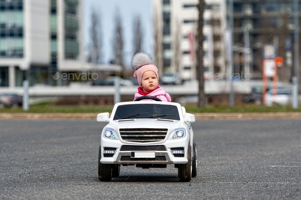 little girl driving a toy car. little driver, childrens car, concept of ...