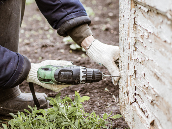 Close-up. A man works with a screwdriver. He screws a screw into the ...