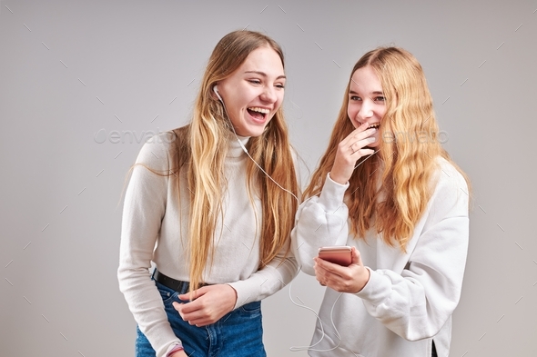 Young women girls listening to music together streaming content having ...