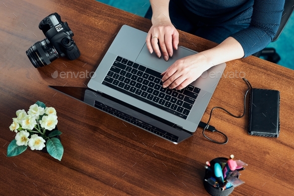 Female photographer working on photos on laptop and camera. Woman ...