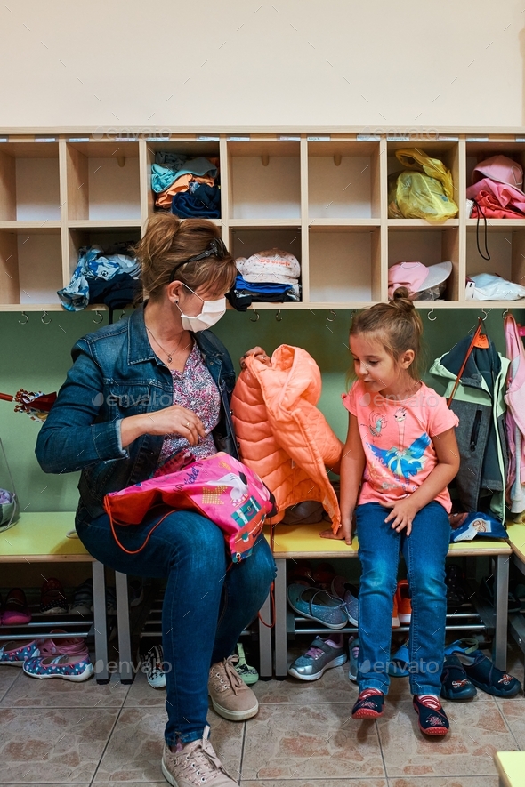 Child little girl changing clothes in changing room in nursery school ...