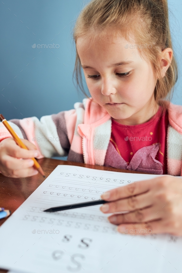 Little girl preschooler learning to write letters with help of her ...