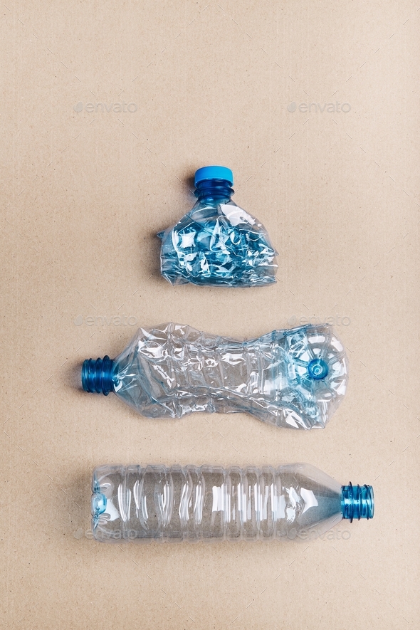 Squashed plastic bottles over cardboard background. Collecting plastic ...
