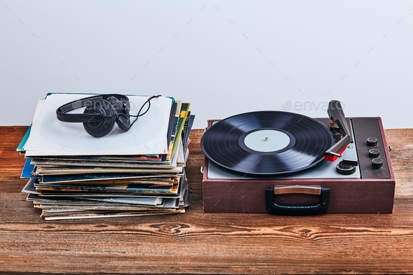 Stack of black vinyl records, turntable vinyl player and headphones ...