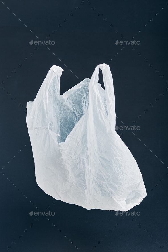 White empty plastic bag floating over black background. Collecting ...