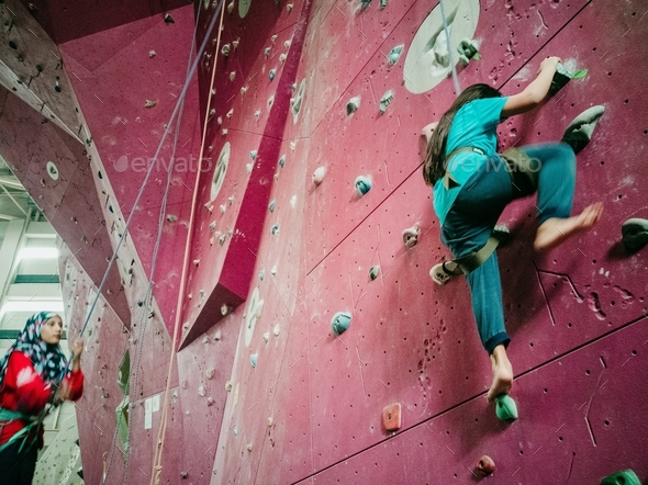 rock climbing practice, young girl and coach Stock Photo by ellinnur