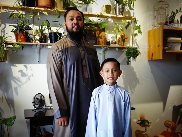 father and son wearing muslim traditional cloth on Hari Raya or Eid ...