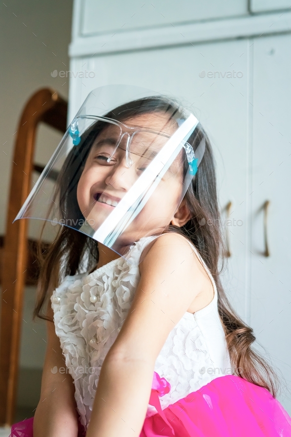 A cute toddler girl wearing the face protection shield. A safety face ...