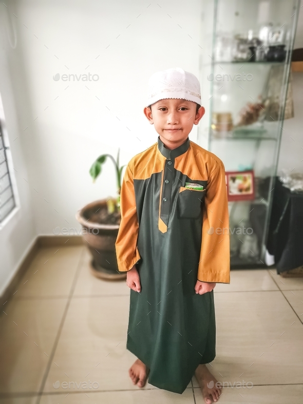 young muslim boy wearing traditional middle east suit jubah during hari ...