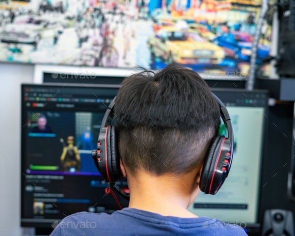 Wearing headphone, A gamer or a streamer boy at home in a room playing ...