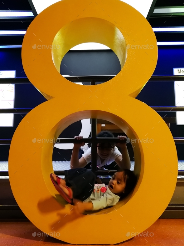 little girl playing on the number eight statue Stock Photo by ellinnur