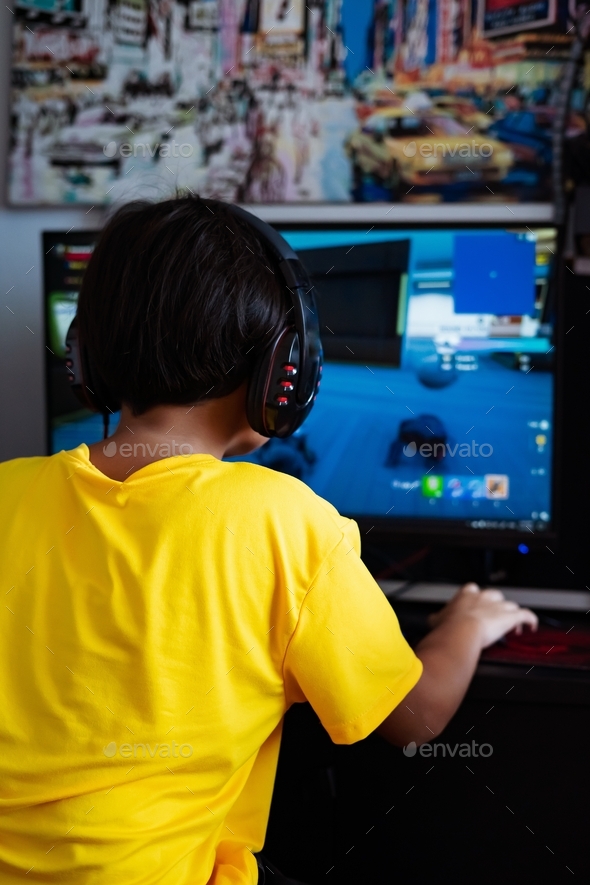 Wearing headphone, A gamer or a streamer boy at home in a room playing ...