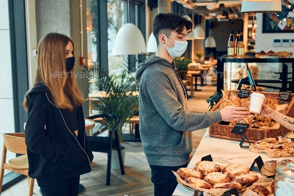 People standing in a queue to buy coffee and pastry in the coffee shop ...