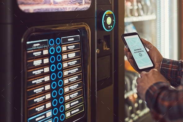 Consumer paying for product at vending machine using contactless method ...