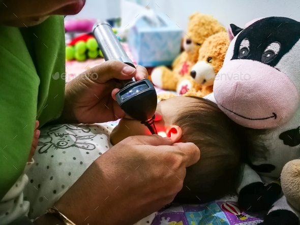 paediatrician checking a baby's ear at the clinic Stock Photo by ellinnur