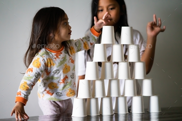 children playing paper cups stacking at home Stock Photo by ellinnur