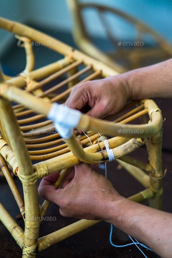 Hand tying a rope to the rattan chair. fixing and upcycling furniture ...