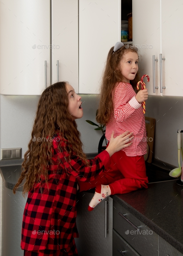 Two girls with candy in the kitchen. New Year. Christmas. Home. Stock ...