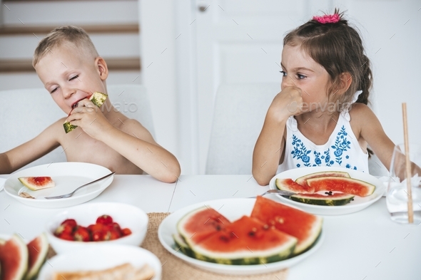 Little boy and girl eating summer food Stock Photo by anita_bonita