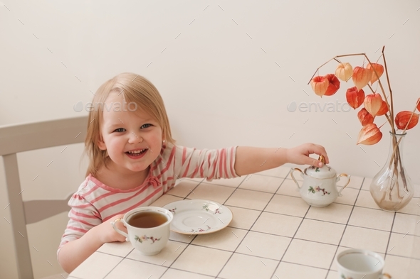 Happy baby girl drinking tea. Child eating breakfast at home Stock ...