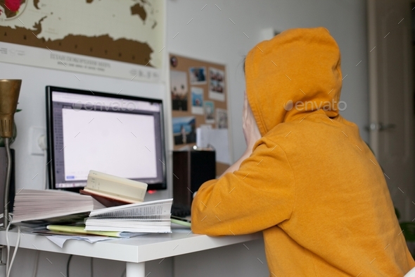 Woman wearing hoodie working remotely at home or studying using ...
